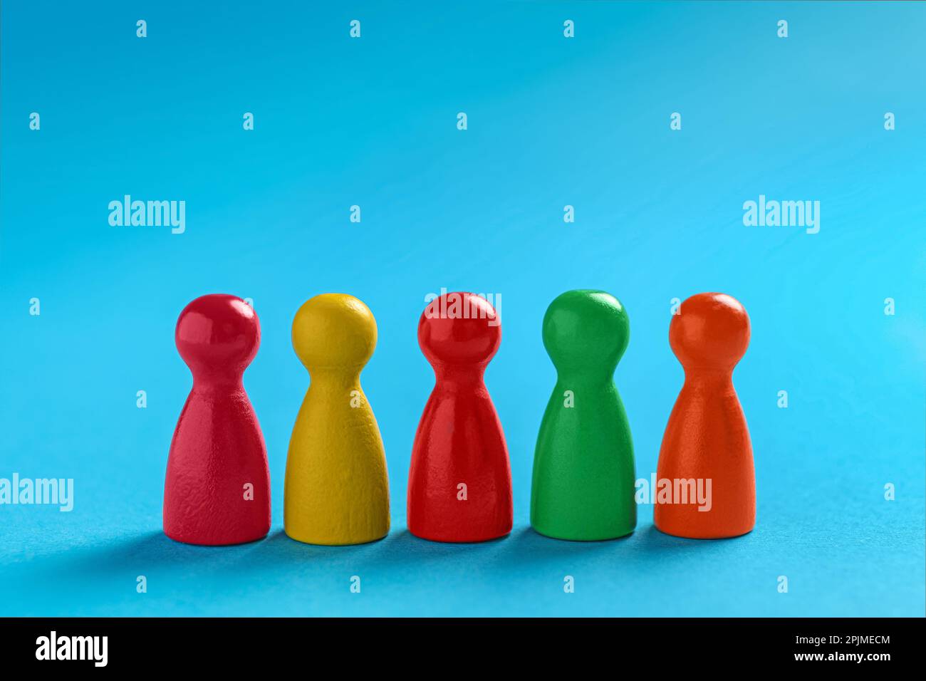 Colorful pawns on light blue background, closeup. Social inclusion ...
