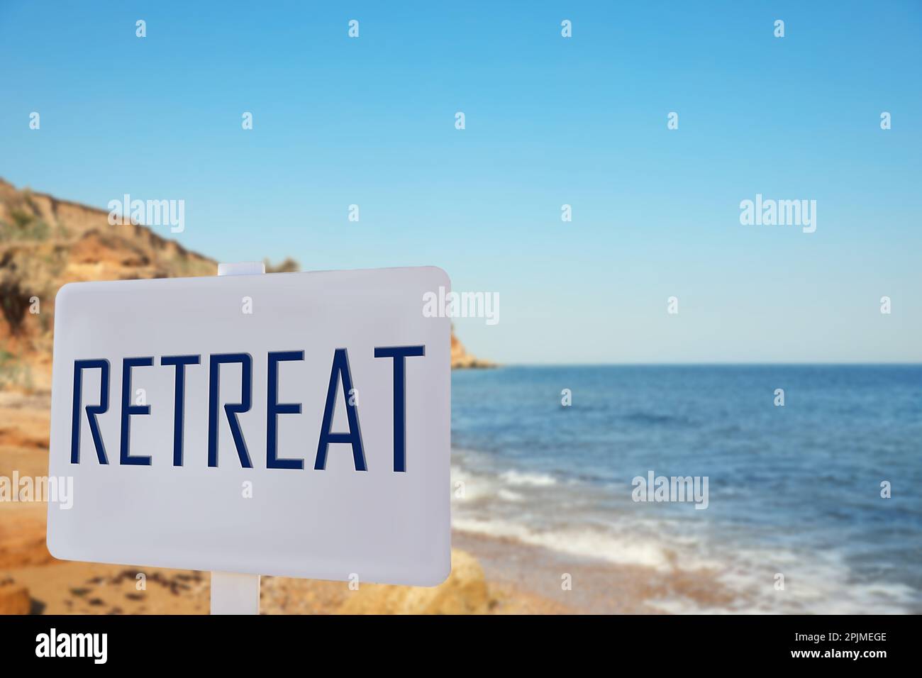 Wooden sign with word Retreat and picturesque view of beautiful beach ...