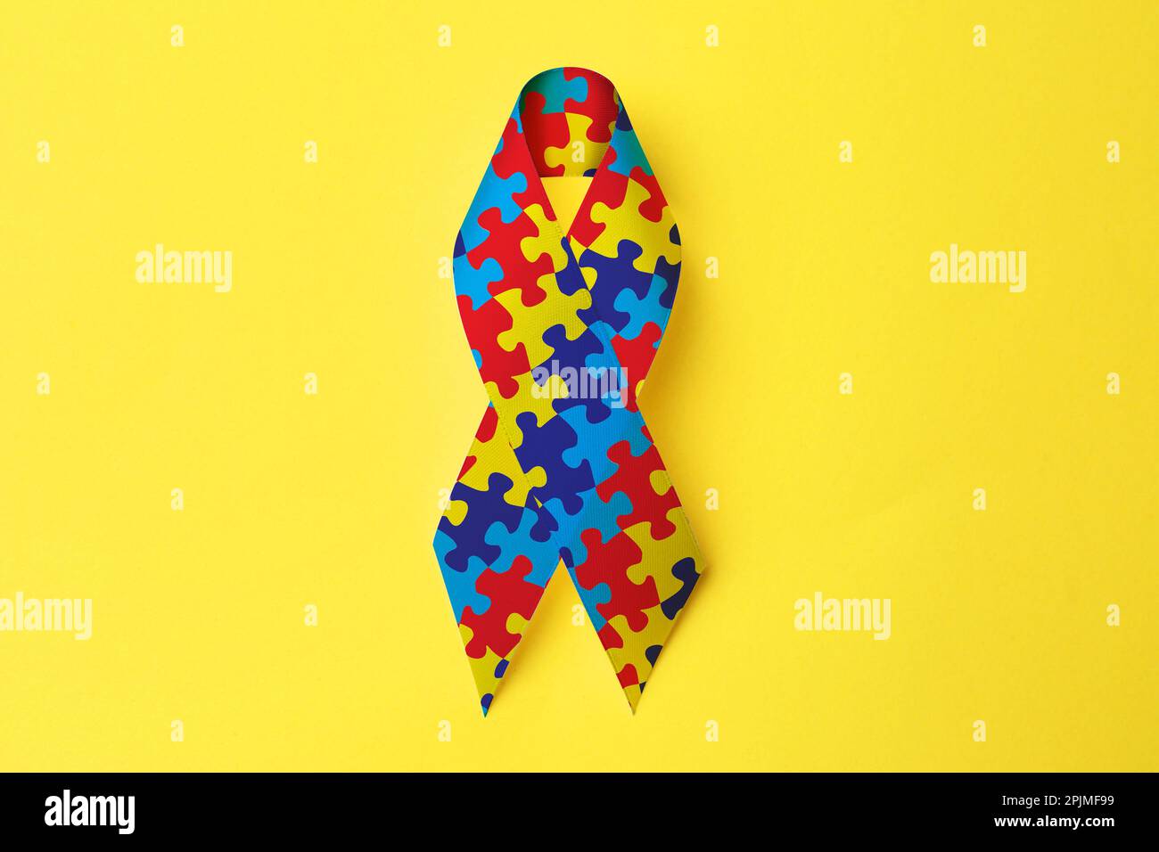 World Autism Awareness Day. Colorful puzzle ribbon on yellow background ...