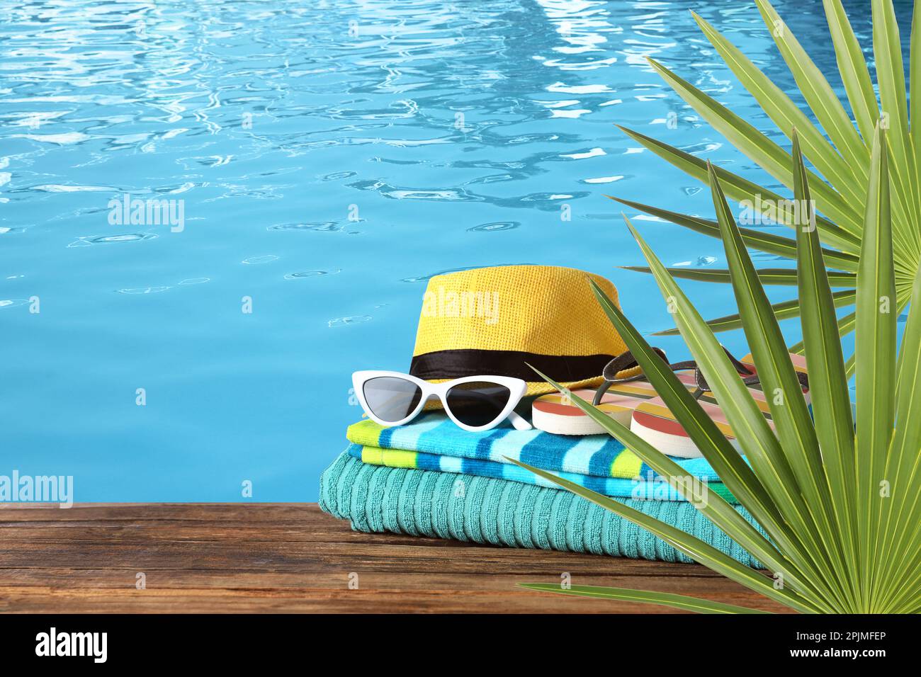 Different beach objects on wooden surface near swimming pool Stock ...