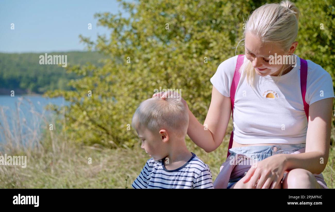 Mom pats her son on the head. She hugs him to her and in every possible ...