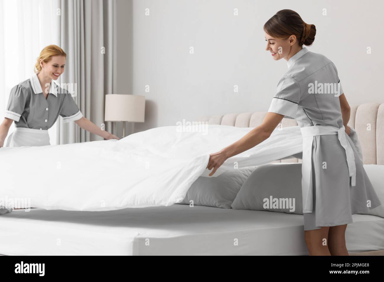 Professional chambermaids making bed in hotel room Stock Photo - Alamy