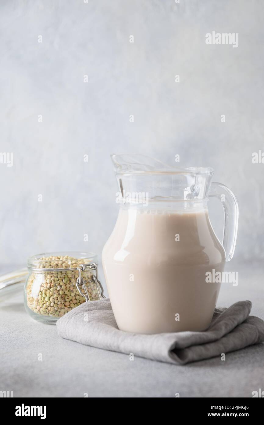 Green buckwheat milk in glass jug on gray background. Alternative plant ...
