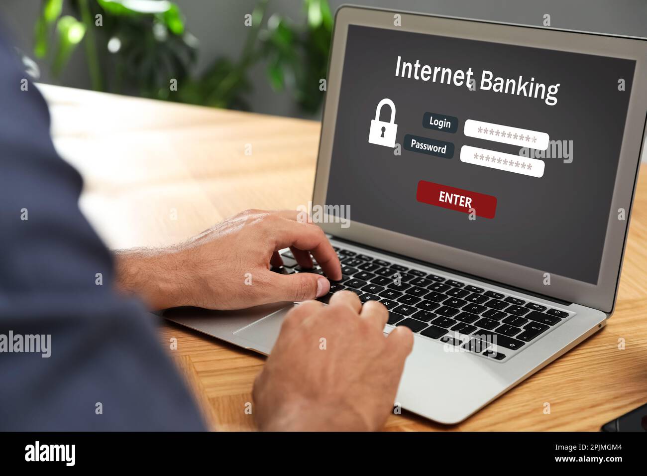 Man using online banking application on laptop at wooden table, closeup ...