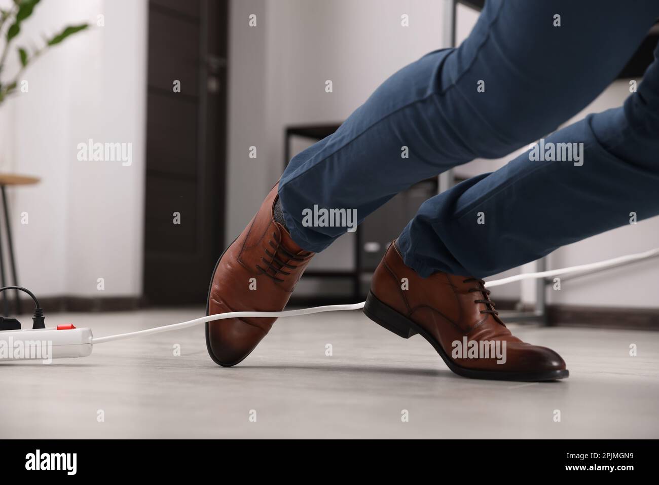 Man tripping over cord in office, closeup Stock Photo - Alamy