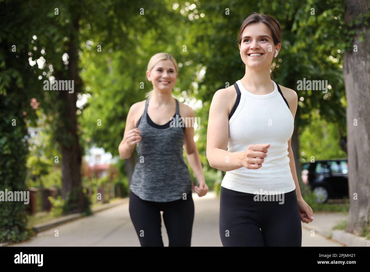 Women running on city street in morning Stock Photo - Alamy