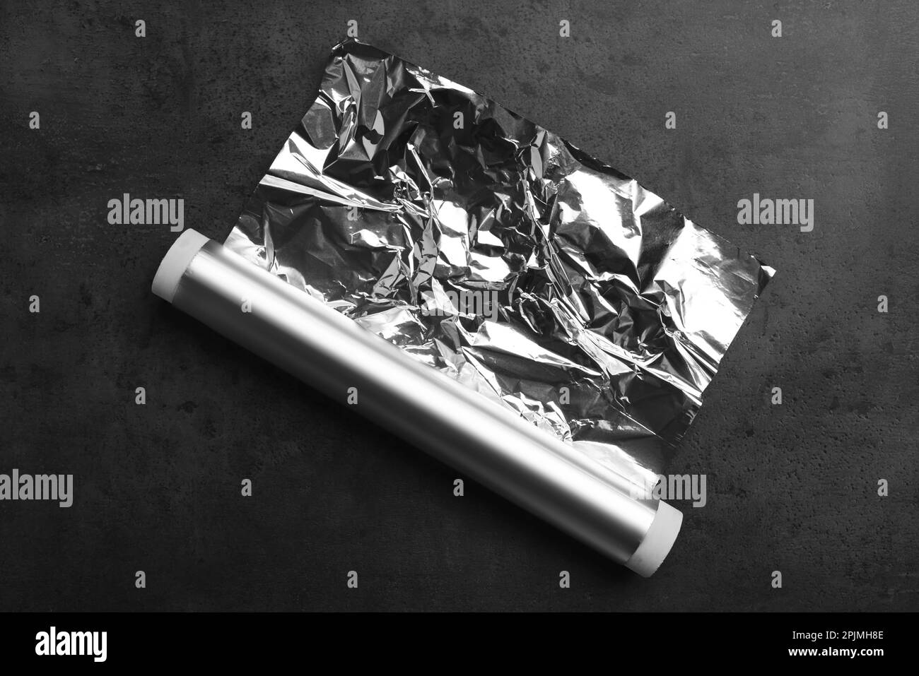 Roll of aluminum foil on dark grey table, top view Stock Photo - Alamy