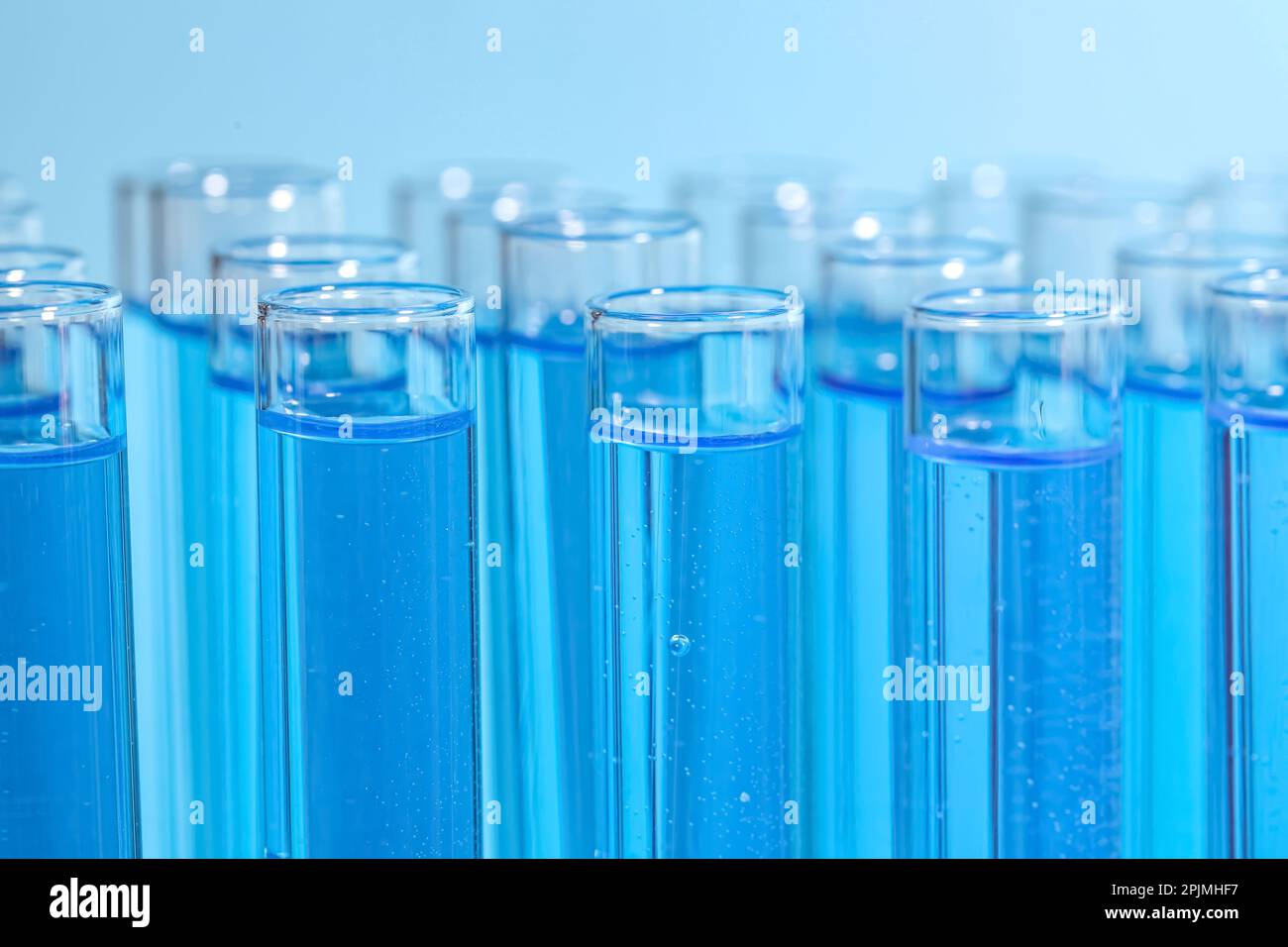 Test tubes with reagents on light blue background, closeup. Laboratory ...