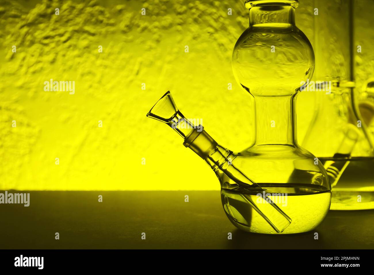 Closeup view of glass bong on table, space for text. Smoking device ...