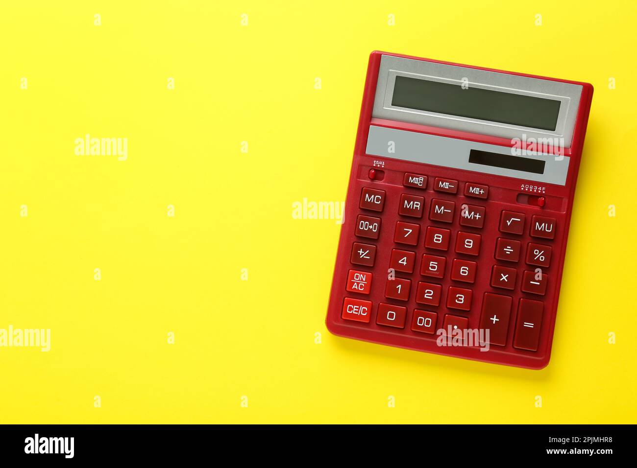 Red calculator on yellow background, top view. Space for text Stock ...