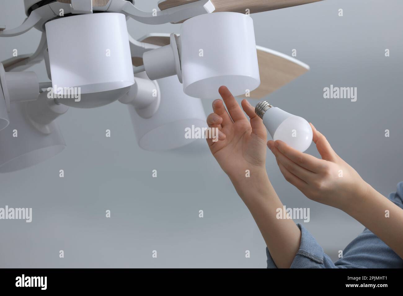 Woman changing light bulb hi-res stock photography and images - Alamy