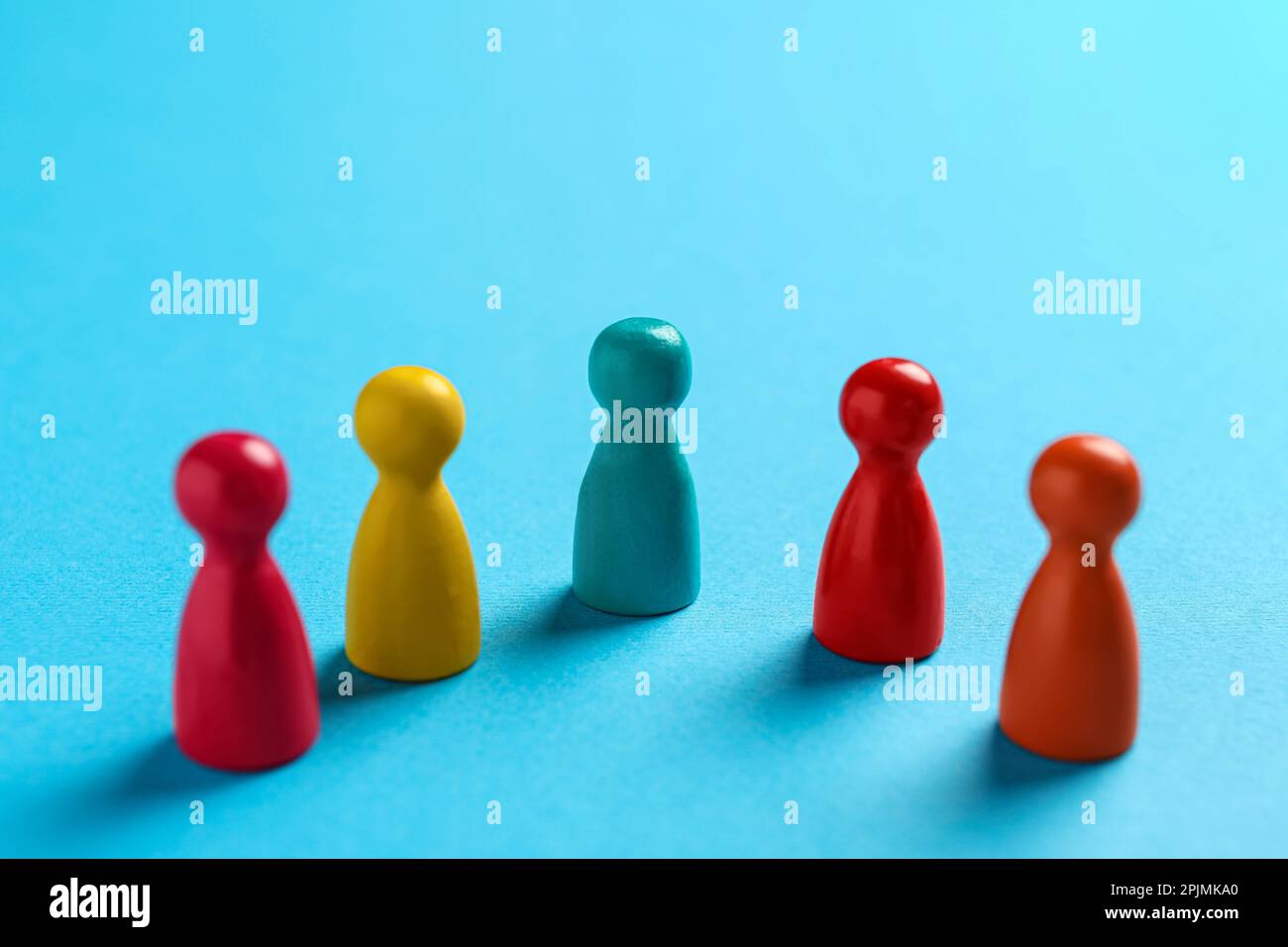 Colorful pawns on light blue background, closeup. Social inclusion ...