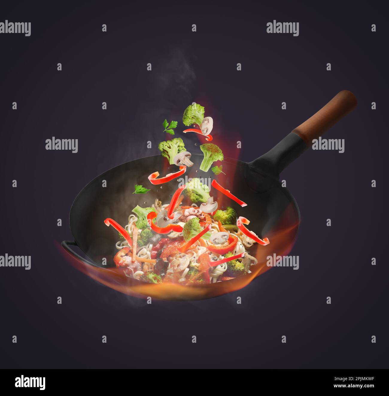 Wok with tasty ingredients and fire on dark background Stock Photo - Alamy