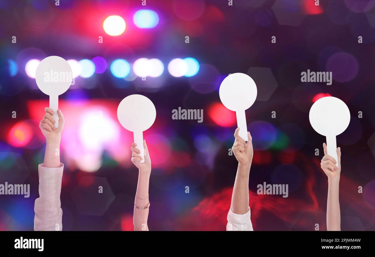Panel of judges holding blank score signs against blurred background ...