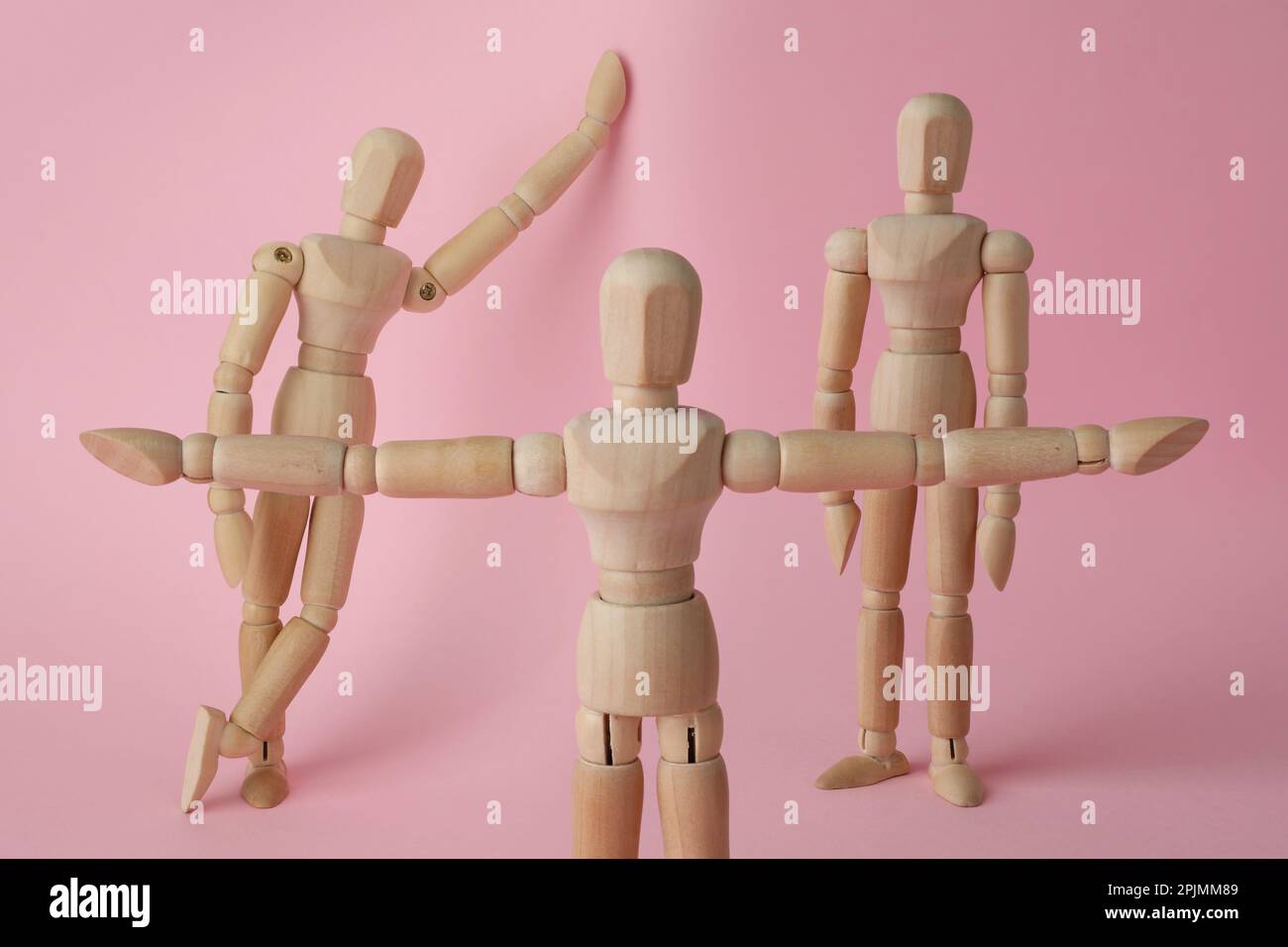 Wooden human models in different poses on pink background Stock Photo ...