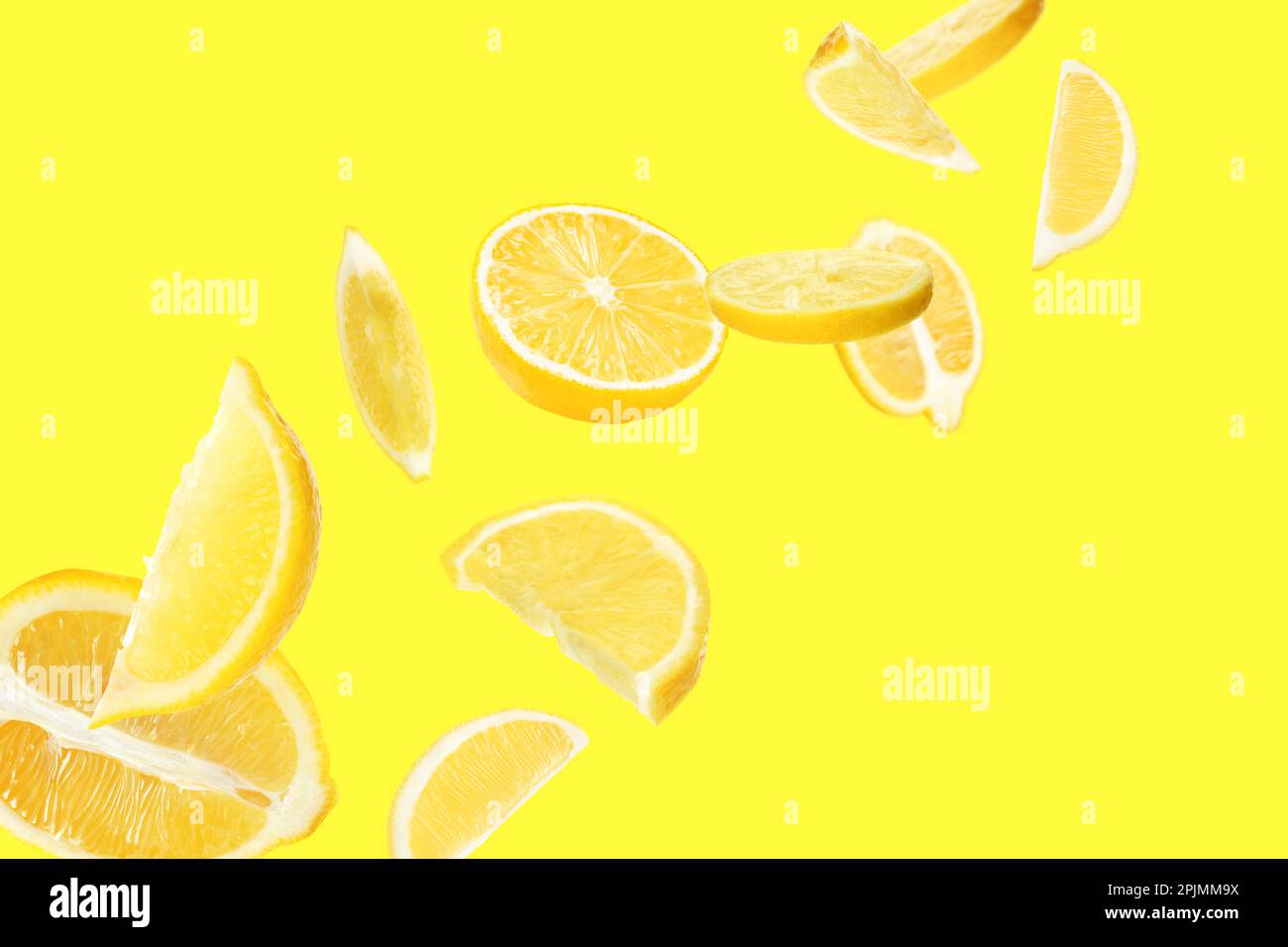 Fresh ripe lemons flying on yellow background Stock Photo - Alamy