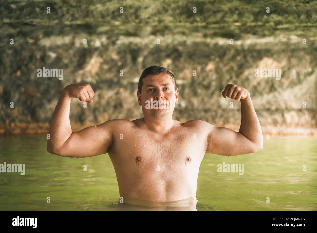 Strong muscular man bathe swim in outdoor cave, dirty hot springs ...