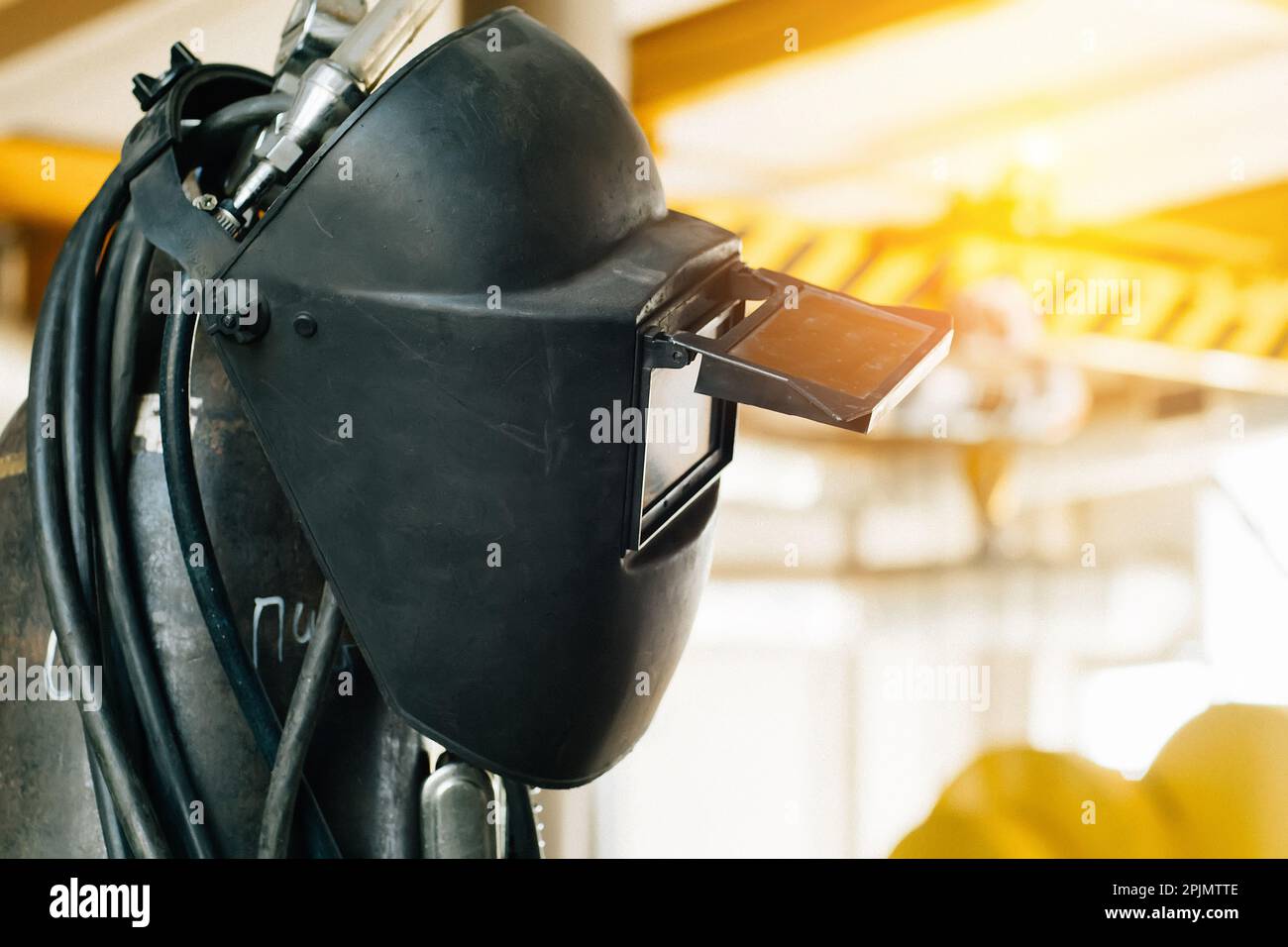 Welder's protective mask hangs on oxygen cylinder in production hall ...