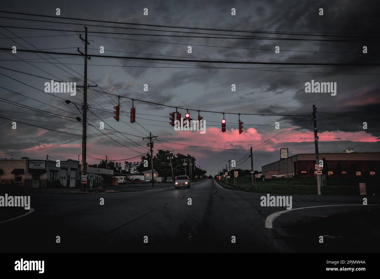 A nighttime street scene illuminated by several red traffic lights in ...