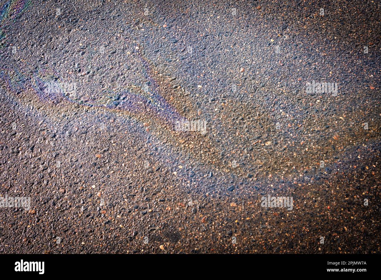 Colored texture of oil products on the asphalt in the rain. Oil dripped ...