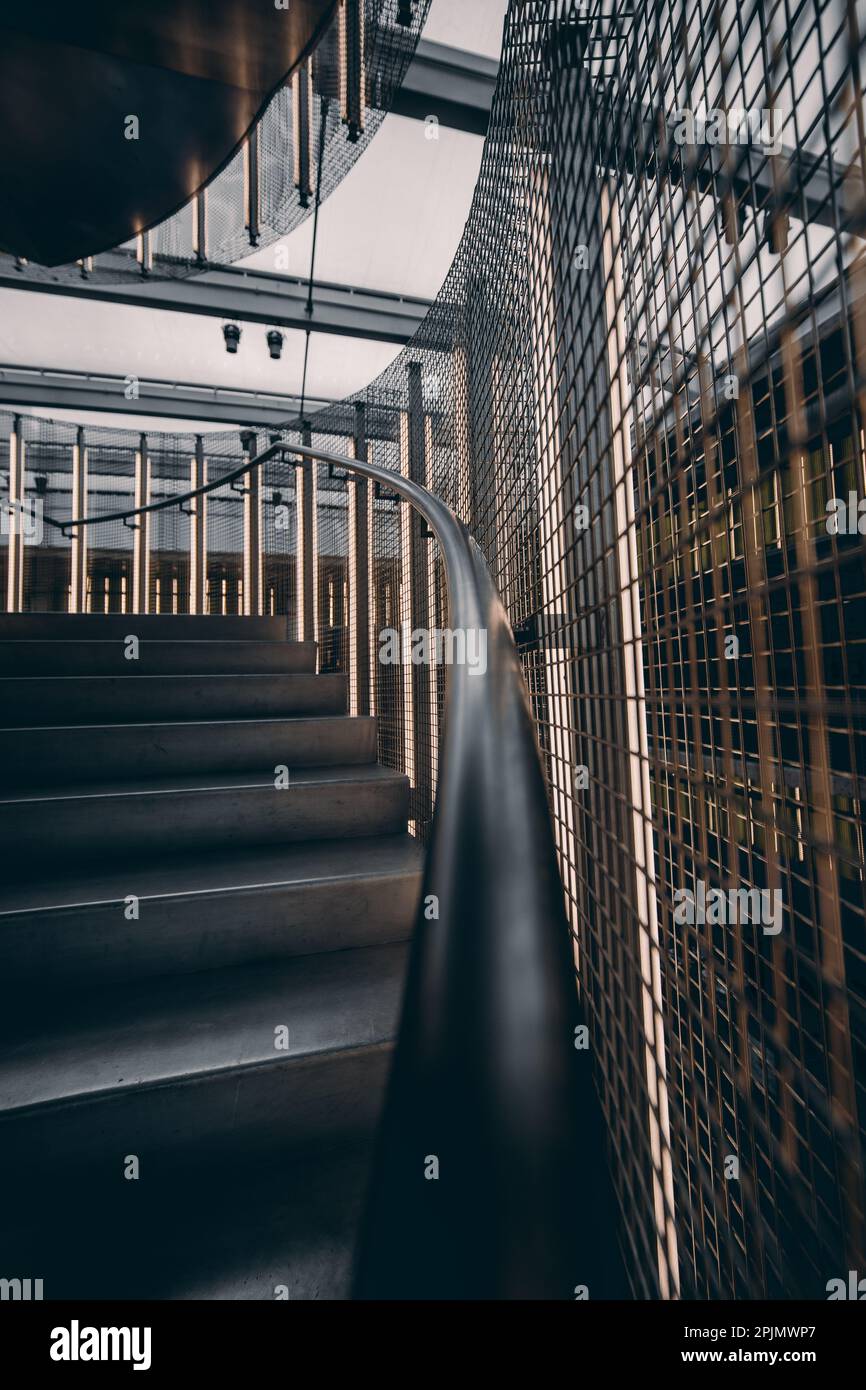 A vertical shot of the stairs of a modern multi-story building in the ...
