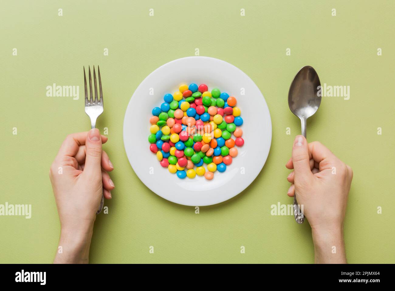 the girl holds cutlery in her hands and eats sweets in a plate. Health ...