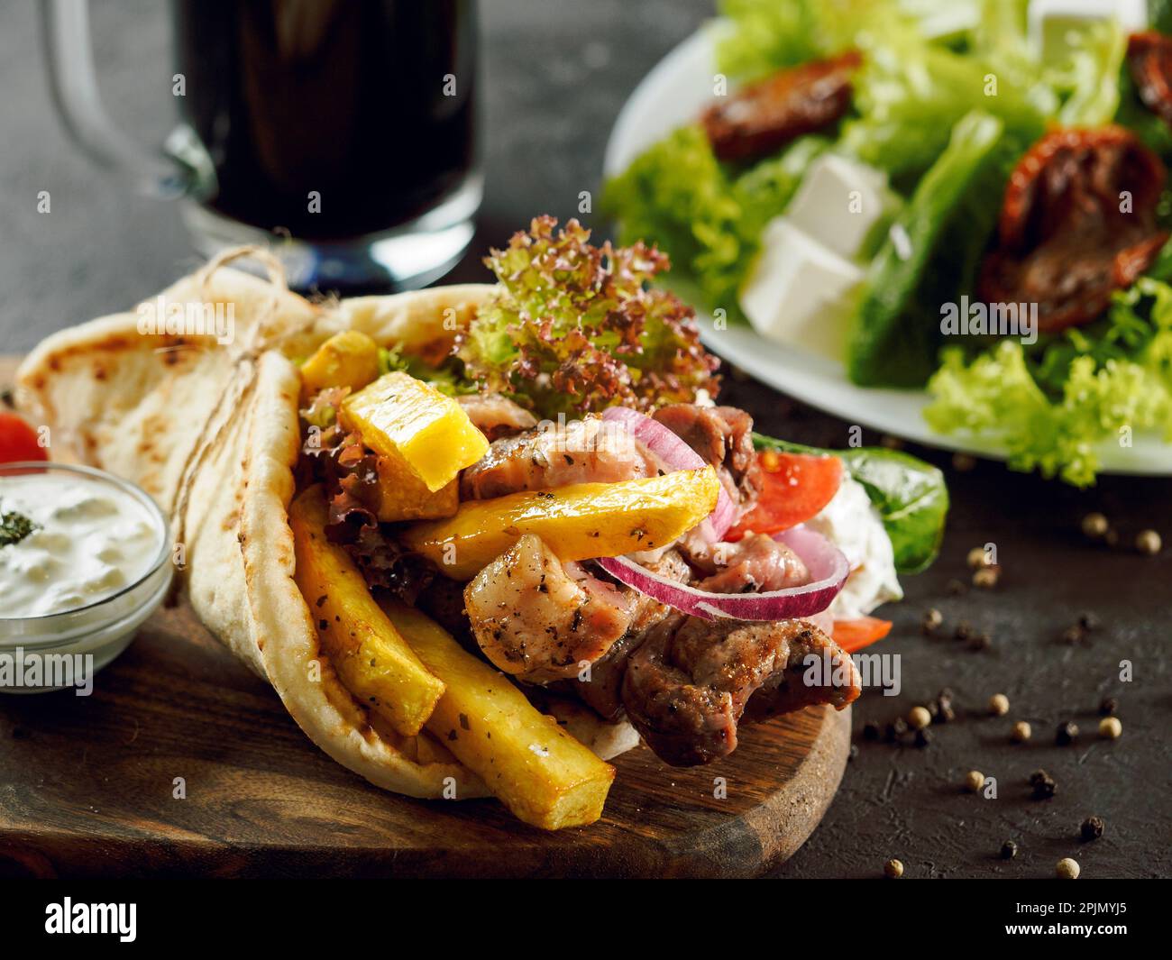 Greek fast food gyros on dark background. Pork grilled meat, fry ...