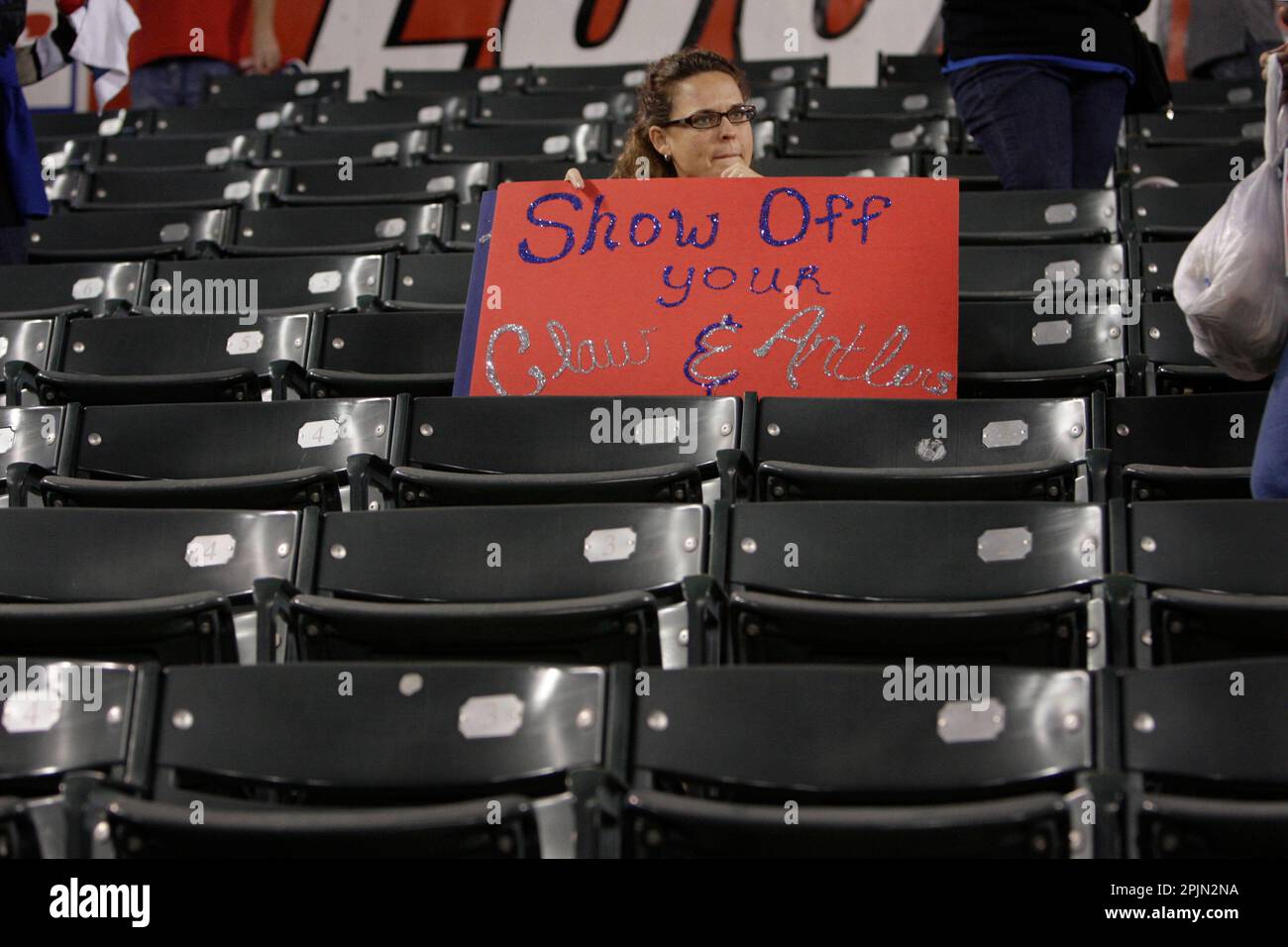 Thresa Belcher of Flower Mound, Texas, sits with her sign as people leave Rangers Ballpark after ...