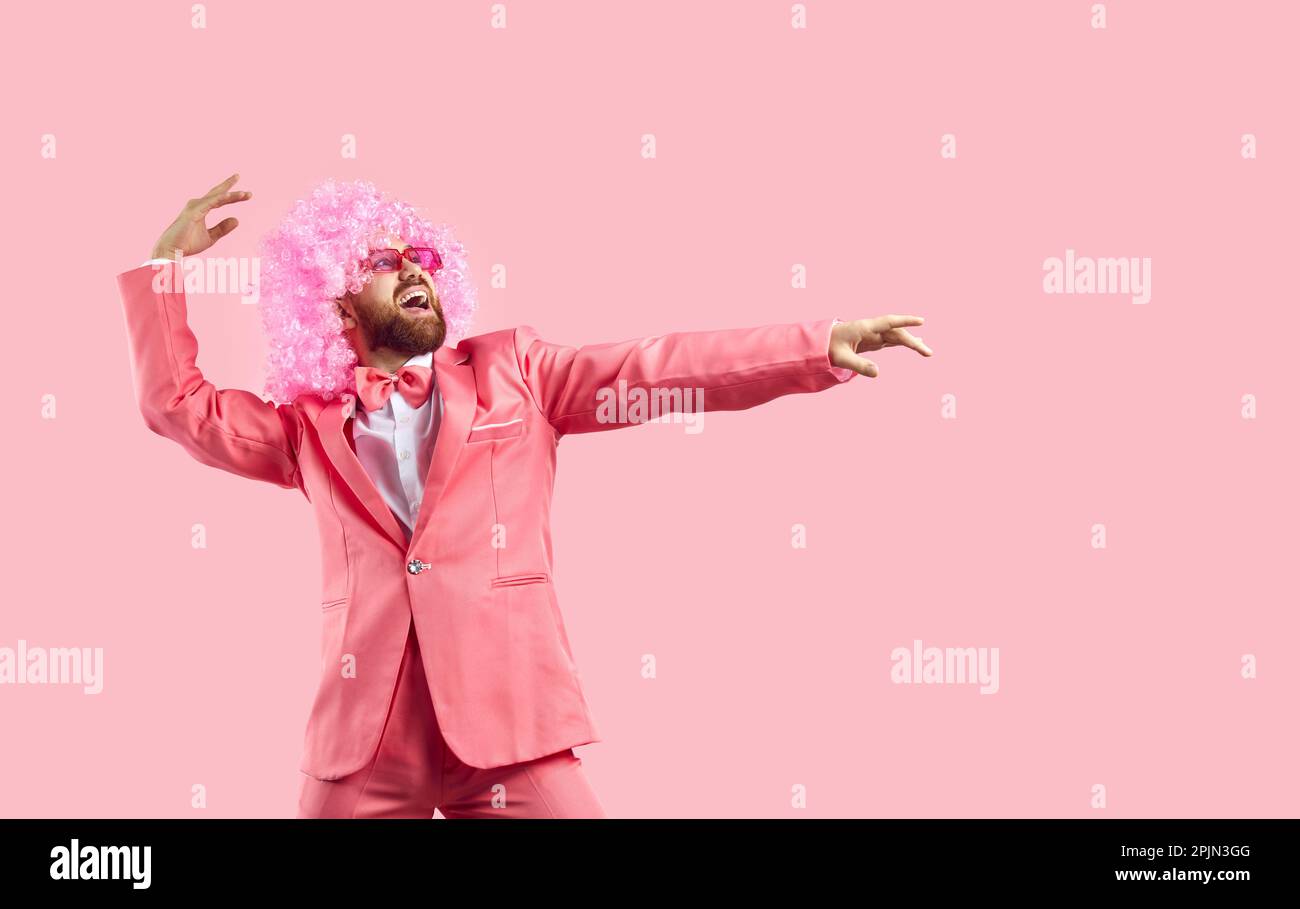 Happy man in funky party suit, funny clown wig and sunglasses dancing ...