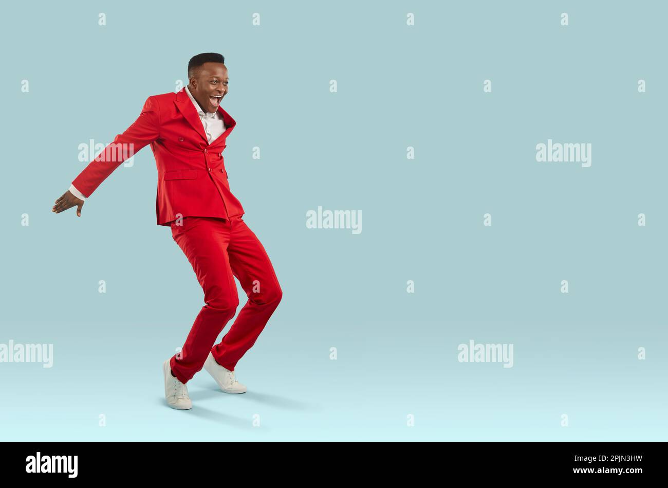 Happy excited African man in red suit dancing and having fun on copy ...