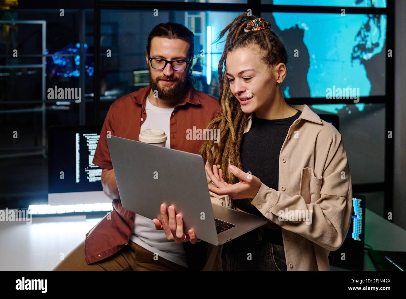 Young confident woman pointing at laptop screen while explaining online ...