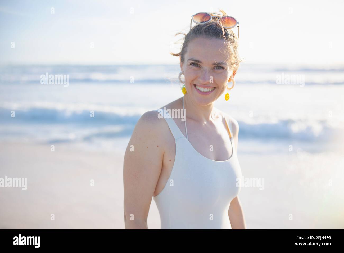 Portrait of happy stylish middle aged woman in white beachwear at the ...