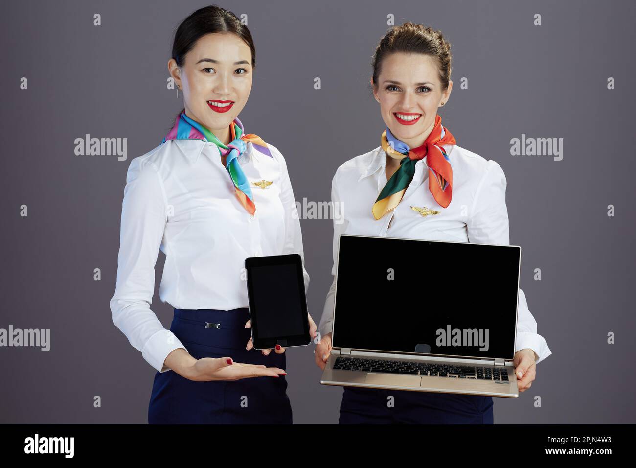 smiling stylish air hostess women in blue skirt, white shirt and scarf ...