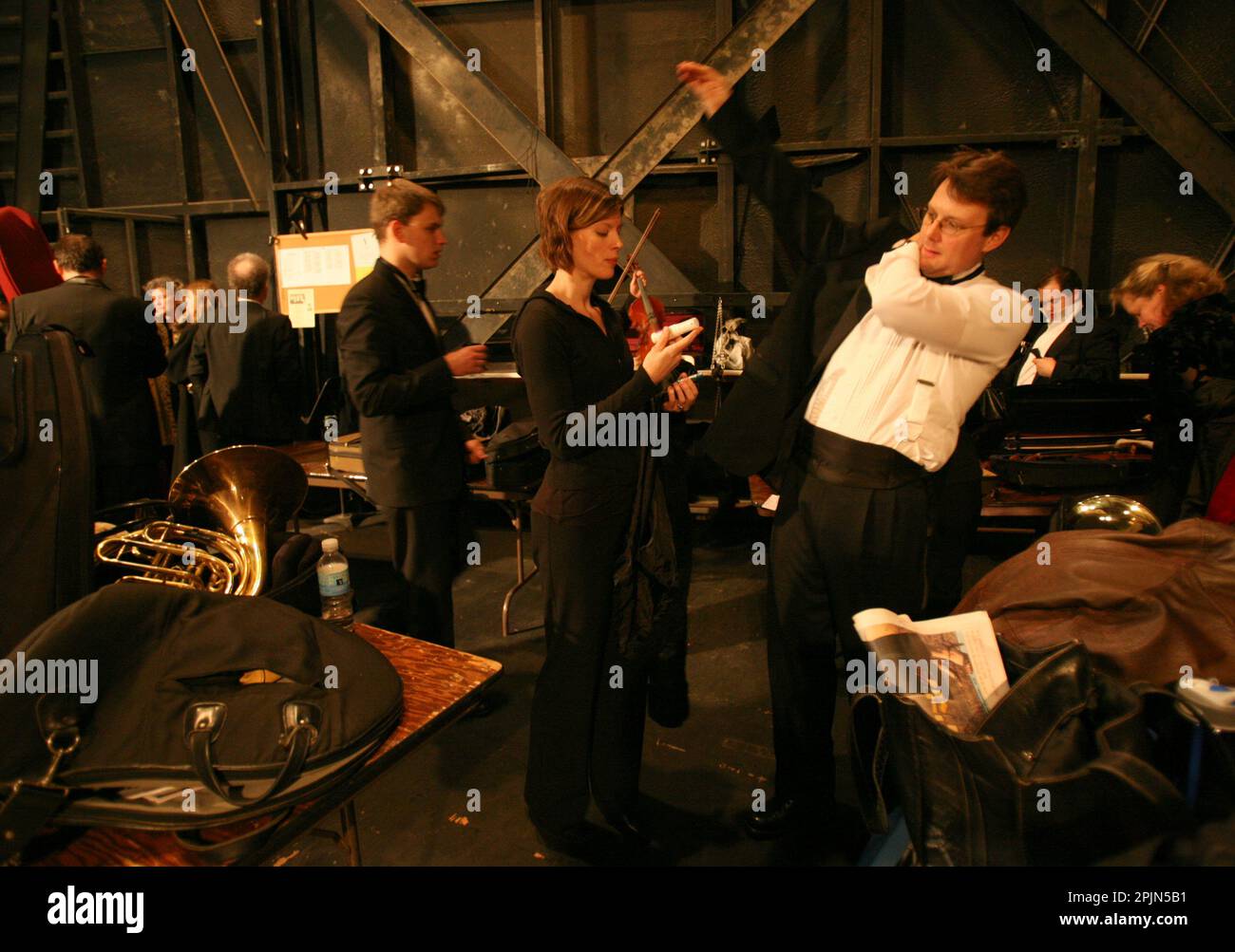 From right; Trombonist Bruce Chrisp puts on his jacket while his wife ...