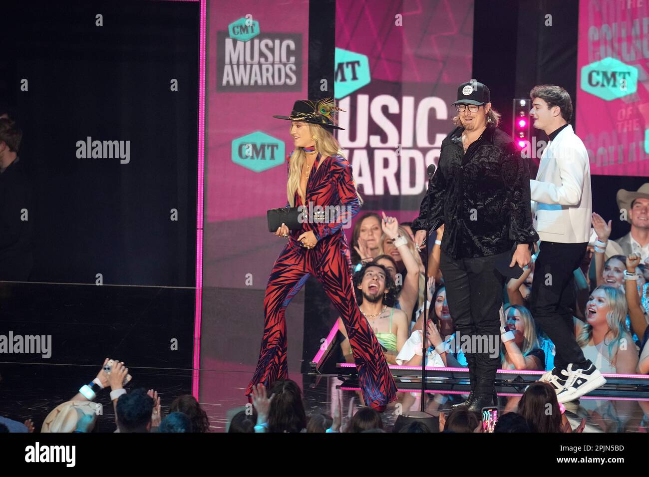 Presenter and singers LAINEY WILSON and HARDY receive an award onstage ...