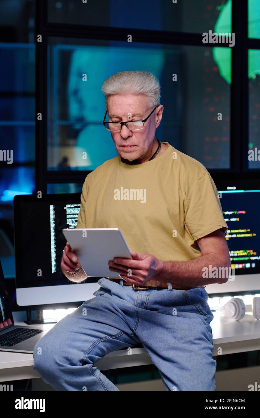 Experienced software developer with tablet sitting on desk against ...