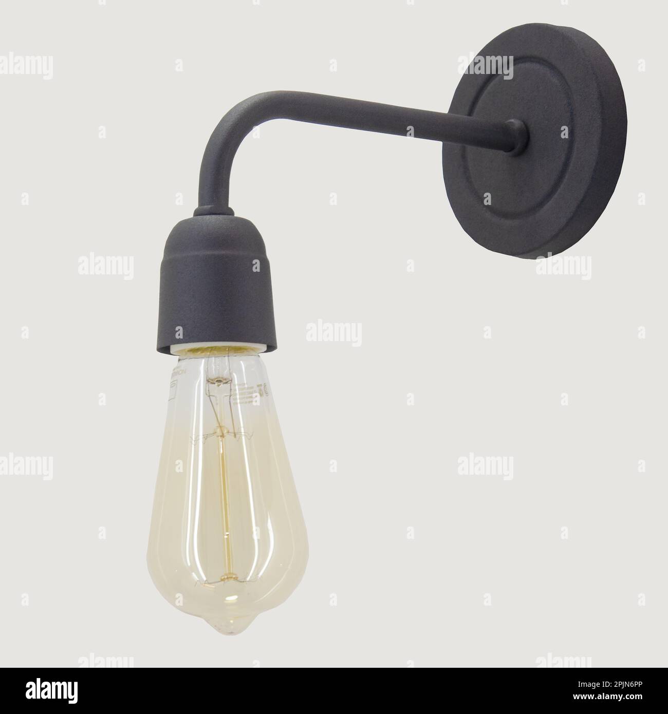 A light bulb is securely mounted to an iron structure on a wall fixture ...