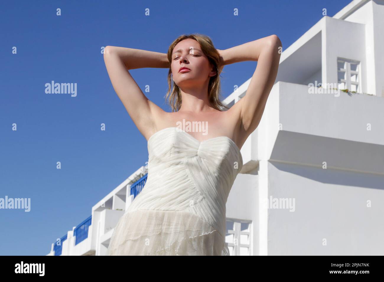 Portrait of the bride in long white wedding dress in the tourist resort ...