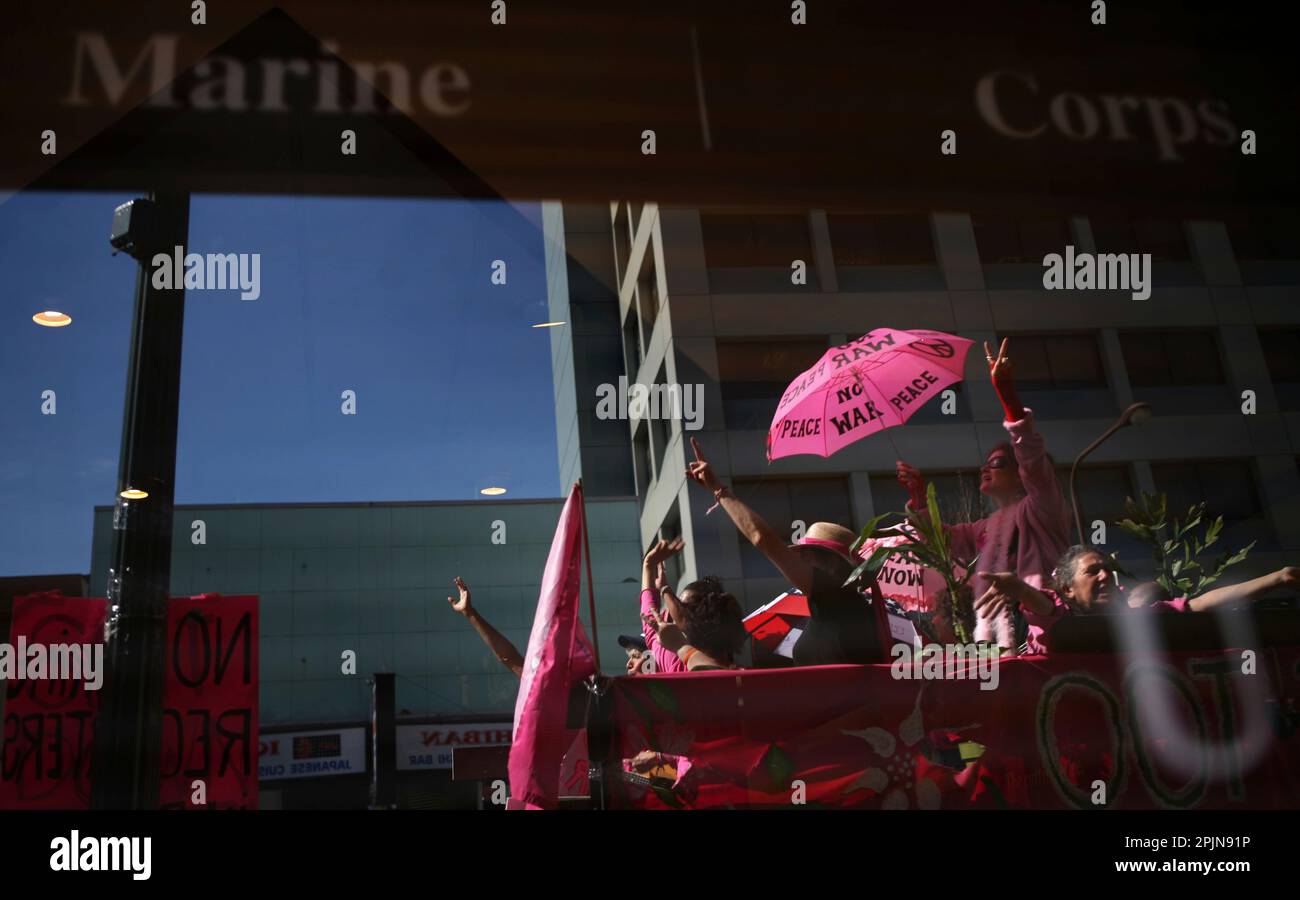 Code pink members sing and wave from the back of a truck to passersby ...
