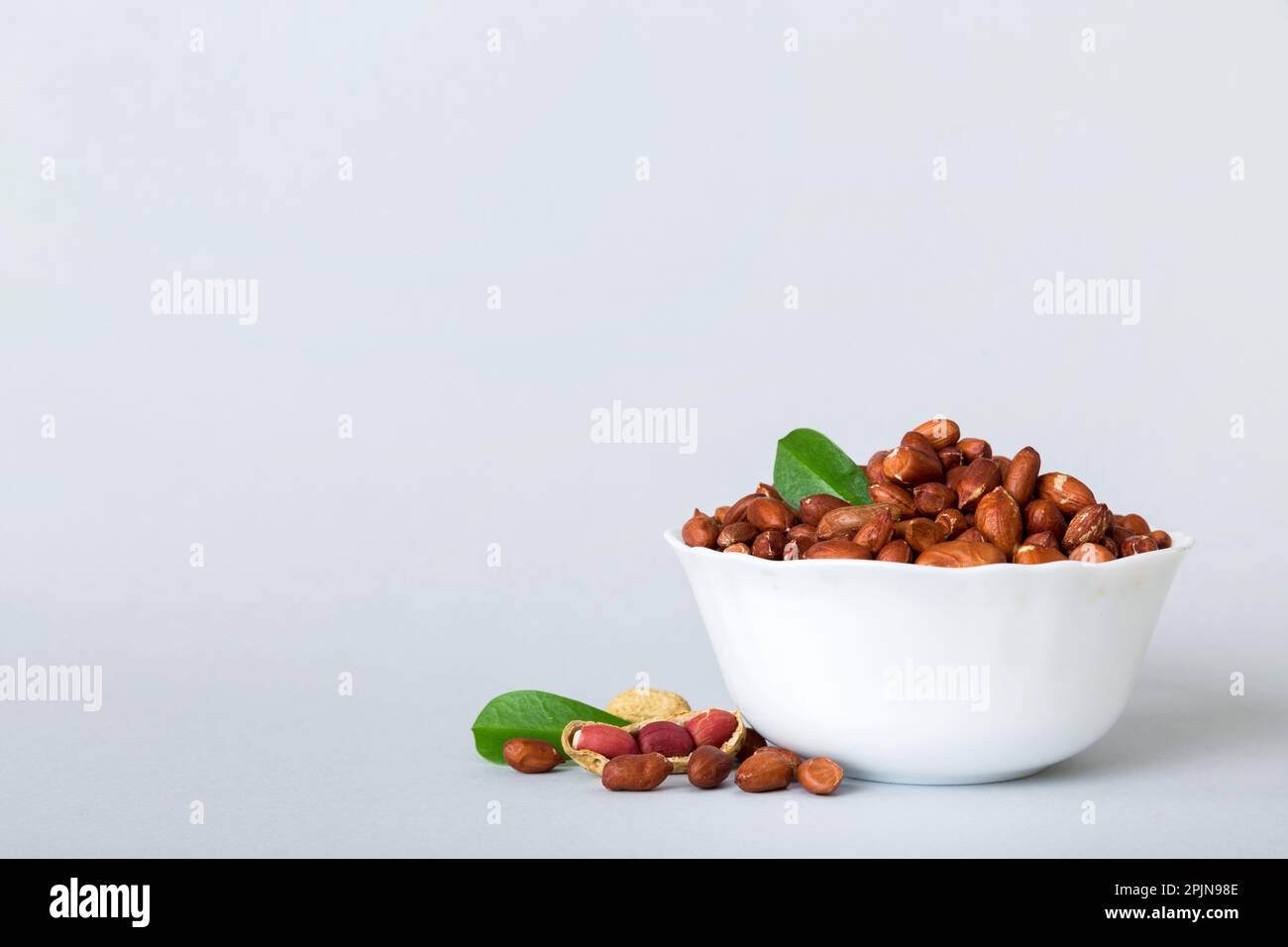 Fresh healthy peanuts in bowl on colored table background. Top view ...