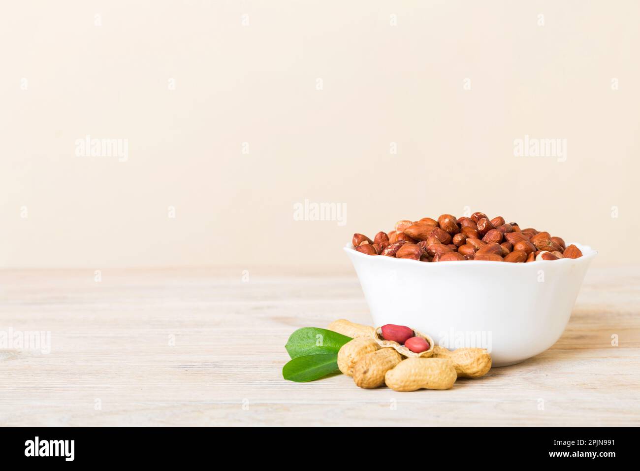 Fresh healthy peanuts in bowl on colored table background. Top view ...