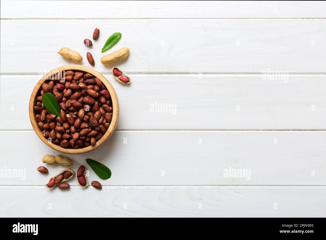 Fresh healthy peanuts in bowl on colored table background. Top view ...