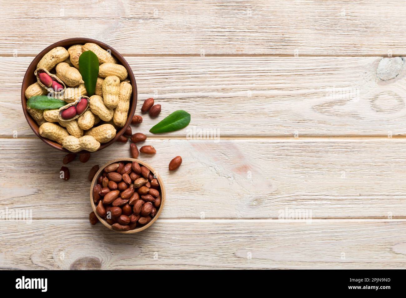 Fresh healthy peanuts in bowl on colored table background. Top view ...