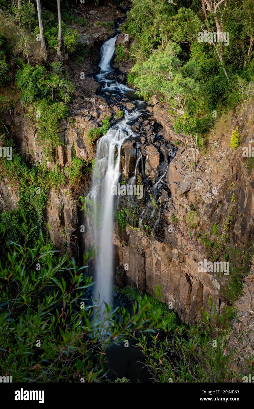 An idyllic natural scene featuring a tall, cascading waterfall ...