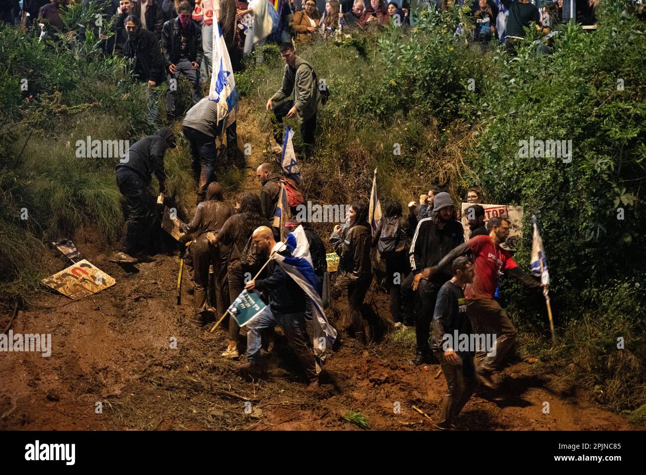 Protestors covered in mud climb up from the Ayalon highway following ...