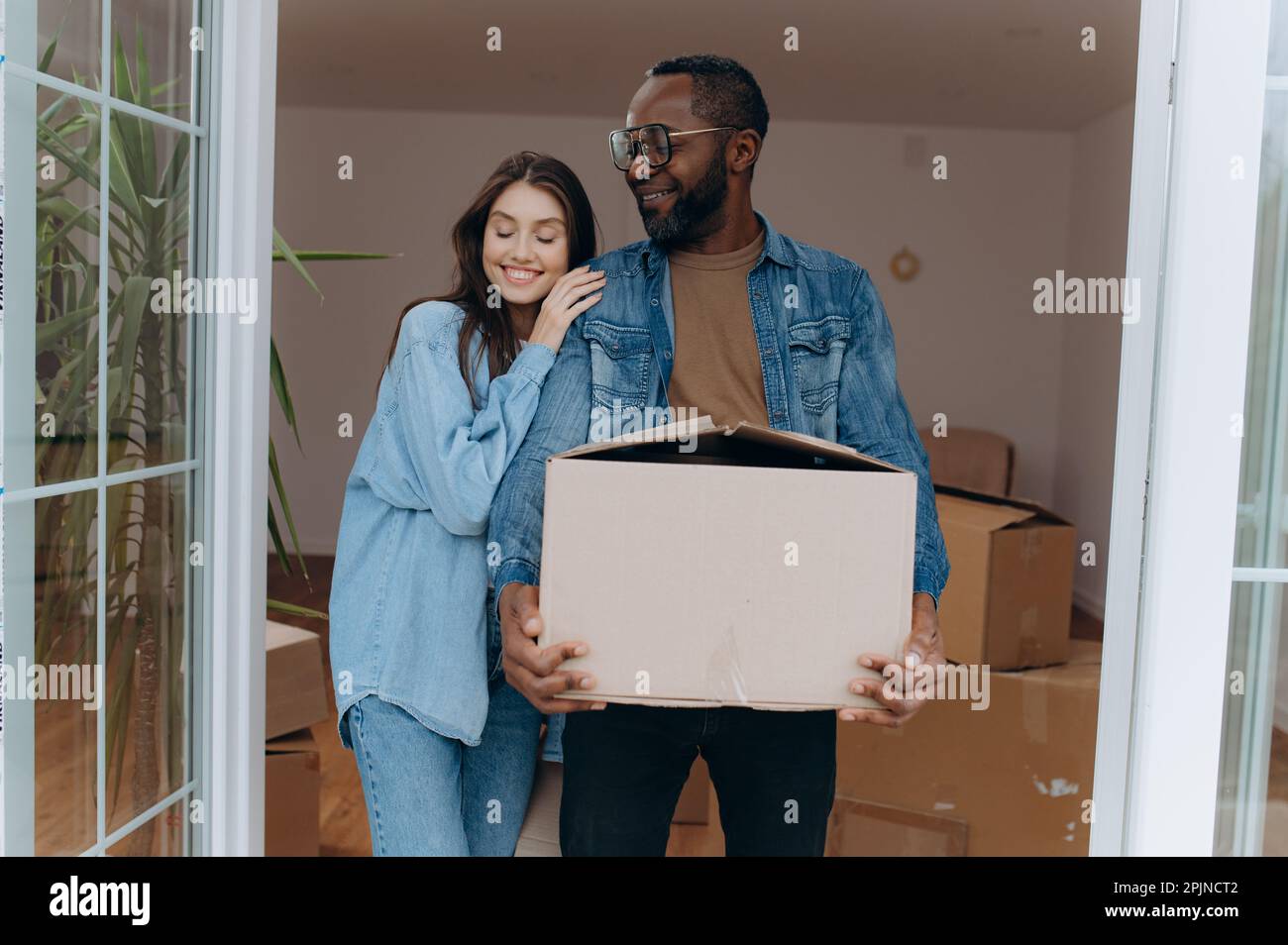 Happy young man hugging excited wife celebrating moving day with ...