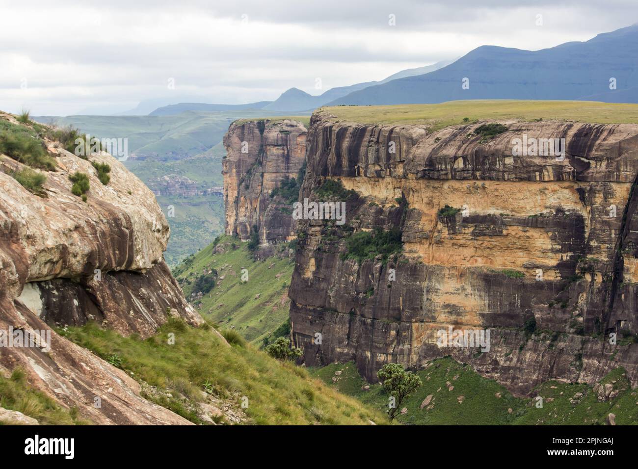 Steep cliffs in the Drakensberg Mountains with the higher peaks in the ...