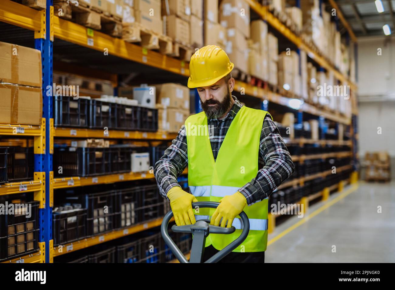 Male warehouse worker pushing a pallet truck Stock Photo - Alamy