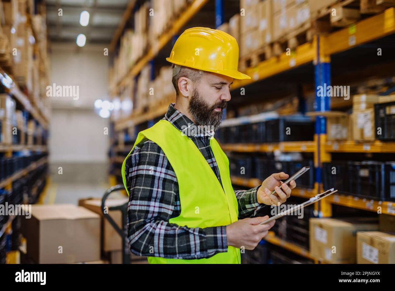 Warehouse worker checking up stuff in a warehouse Stock Photo - Alamy