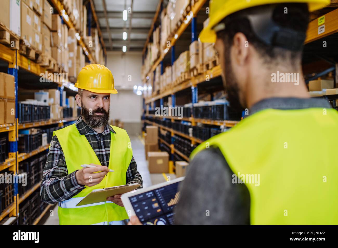 Warehouse workers checking stuff in warehouse with digital system in ...